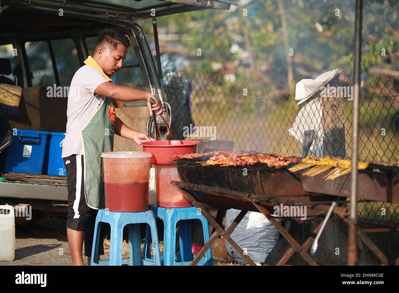 Photo of a man cooking street food at a local market Stock Photo - Alamy