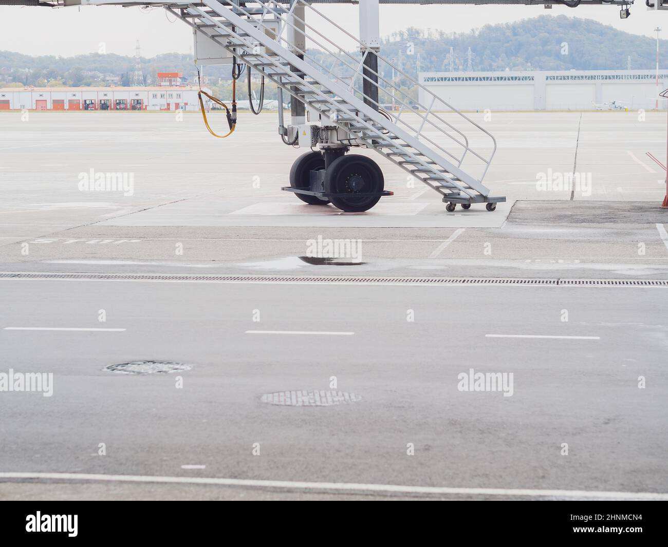 An aircraft ladder on wheels on a wide runway. Fragment of telestair ...
