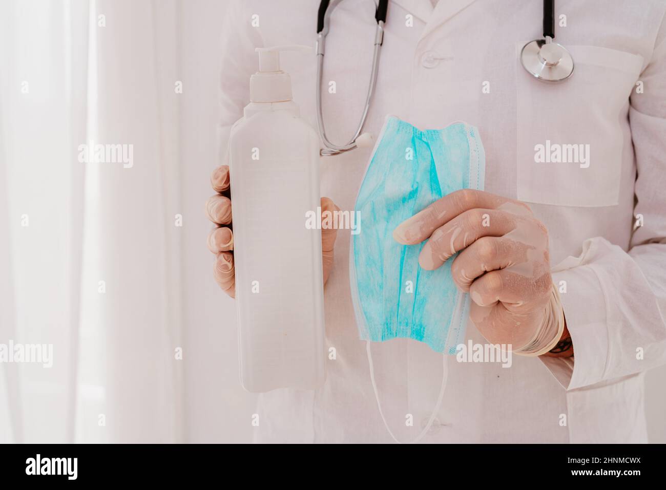 Doctor shows a disinfectant gel and a face mask for covid-19 Stock ...