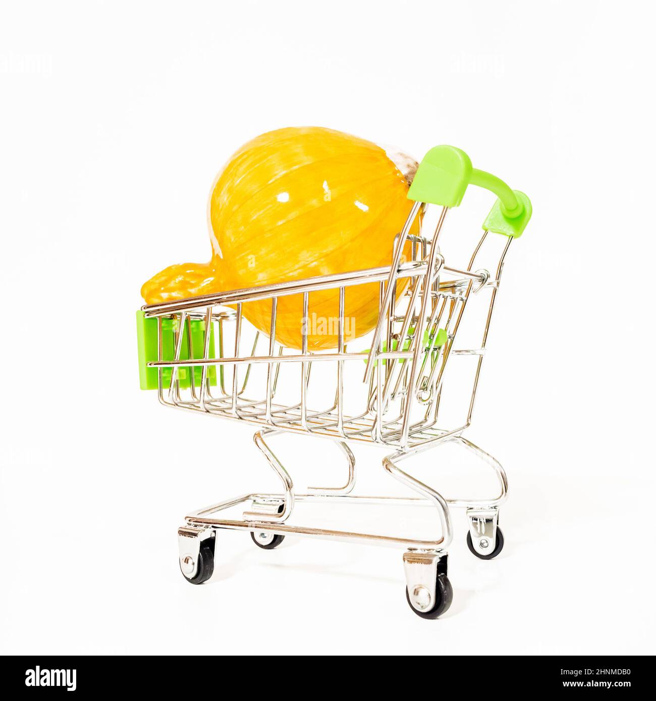 A yellow shiny fake onion lies in a tiny toy supermarket trolley on ...