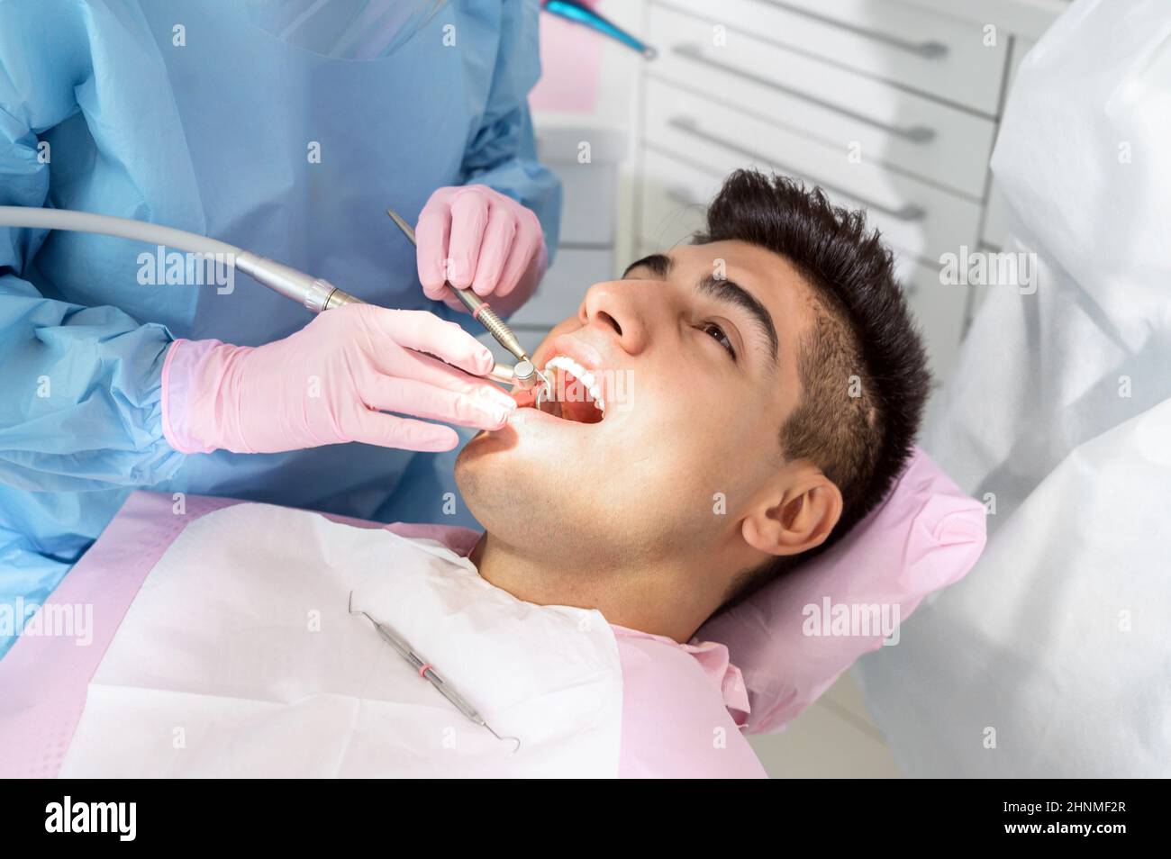 Young man having teeth examination at dentist office. Professional oral ...