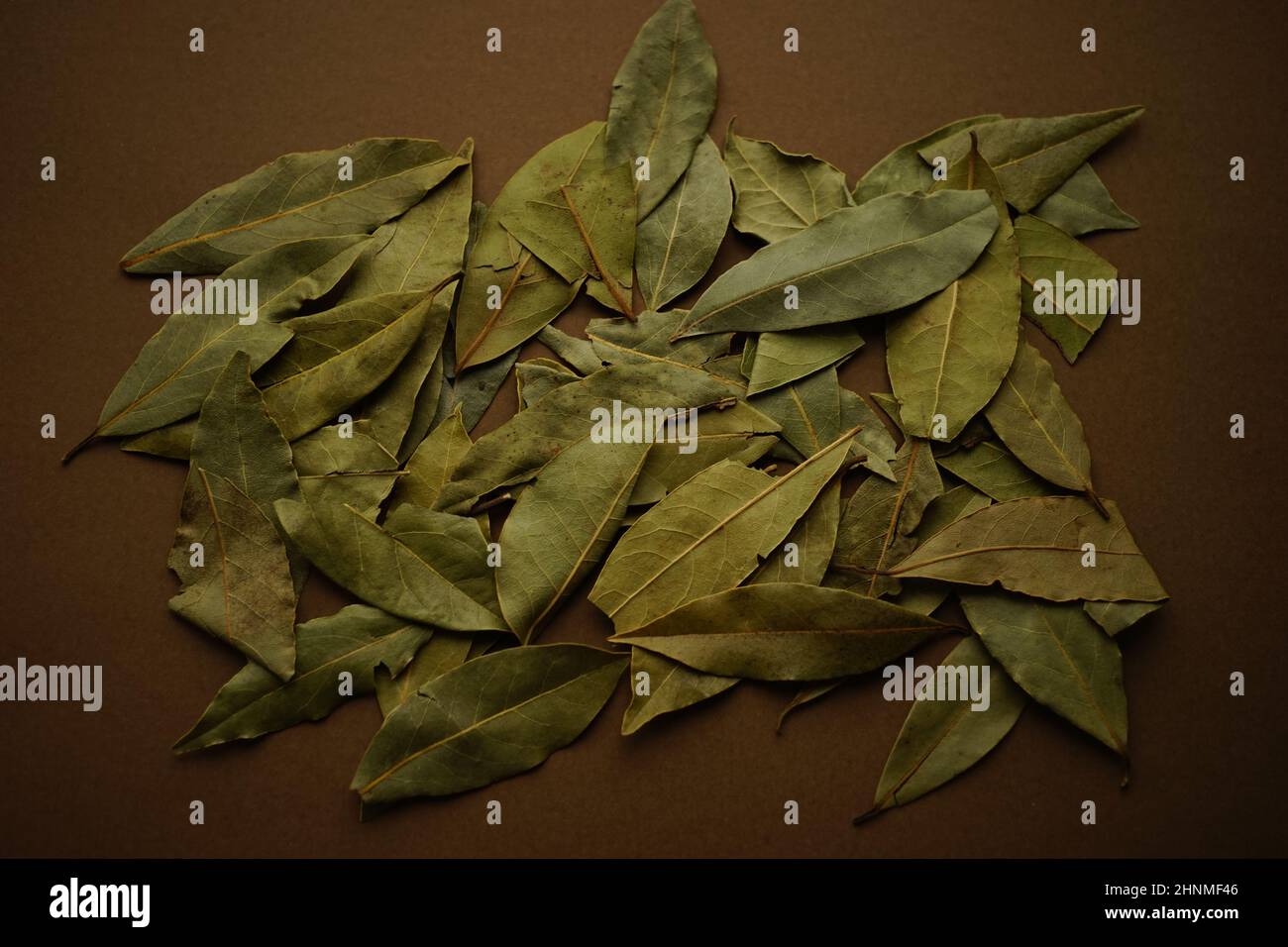 Heap of dry green bay leaves on brown table. Top view Stock Photo - Alamy