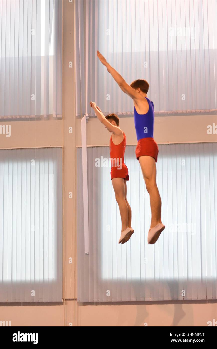 Boys train in synchronized jumping on a trampoline Stock Photo - Alamy