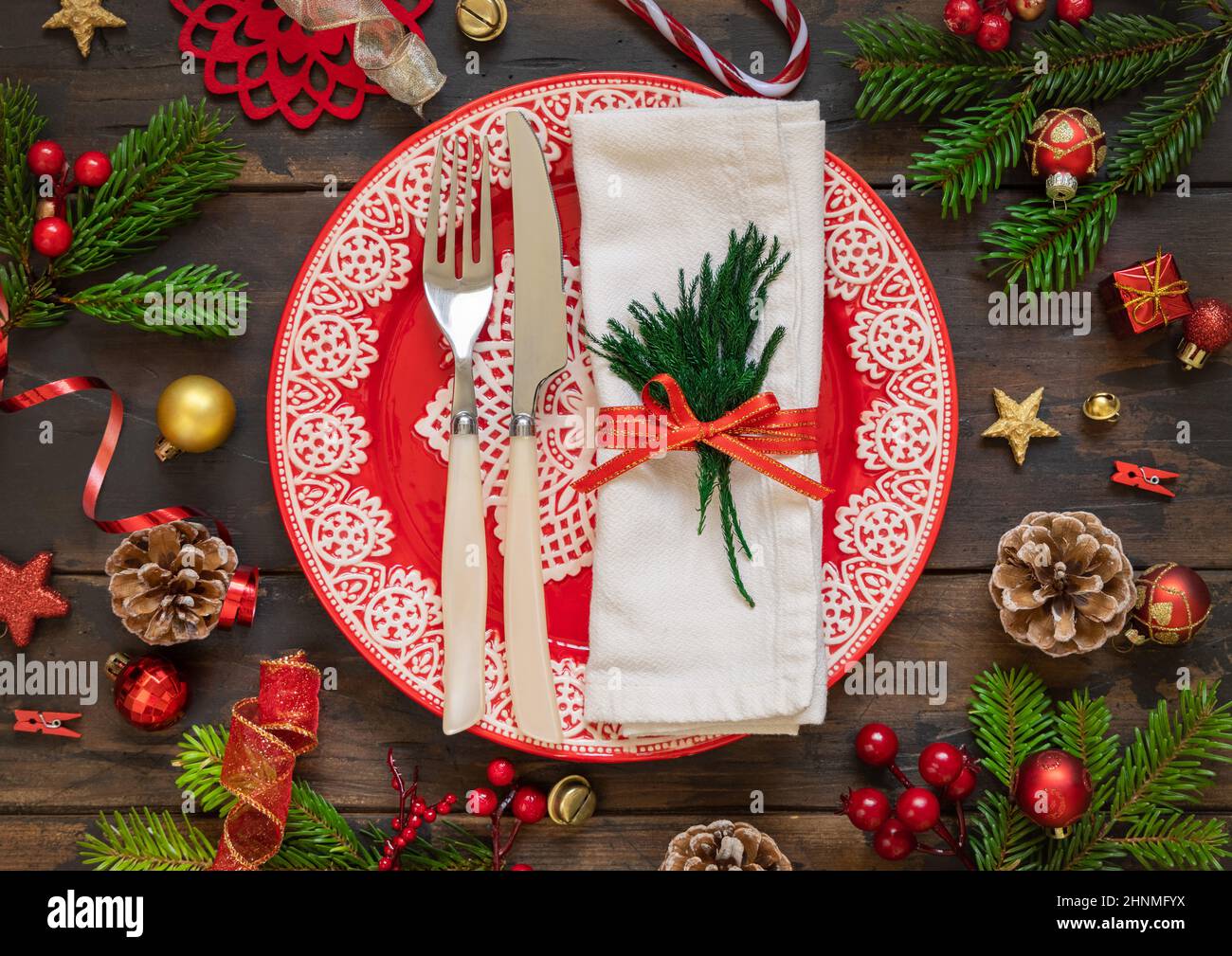 Festive table setting with ornaments and fir tree branches on a wooden ...