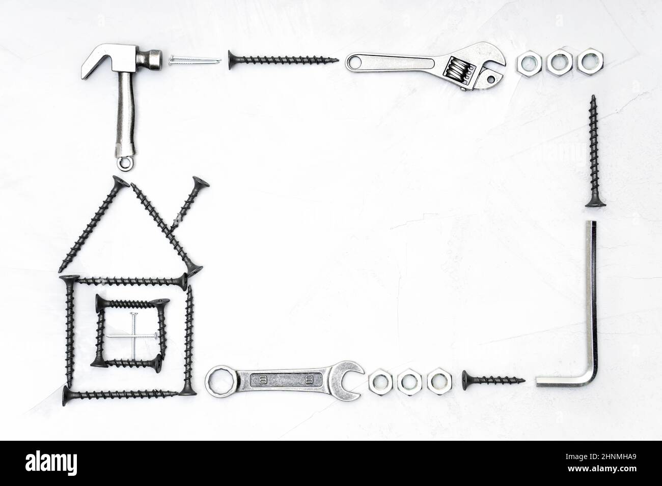House shape made from screws with essential hand tools and fasteners ...