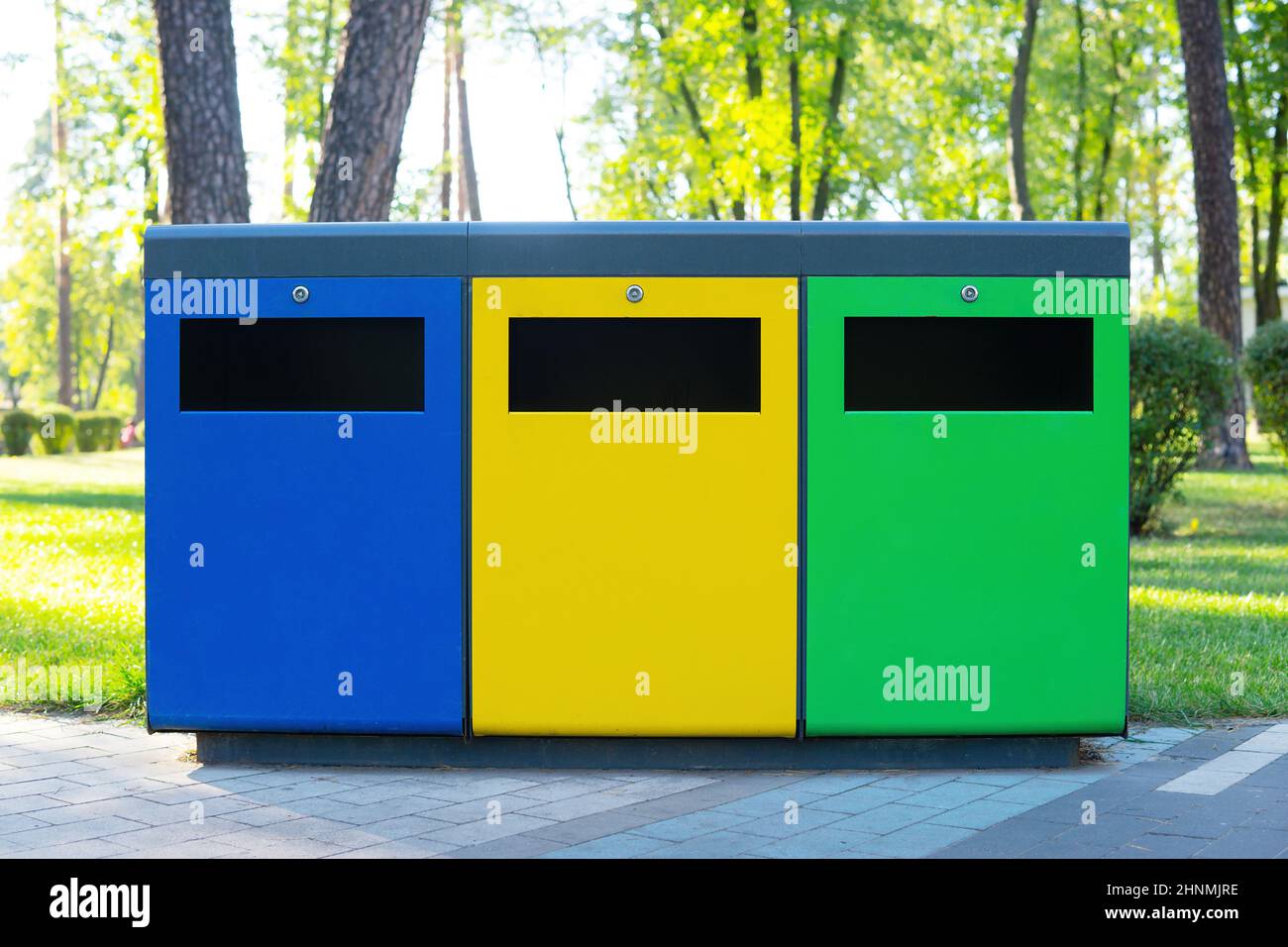 Three colored garbage bins for waste collection and sorting in the ...