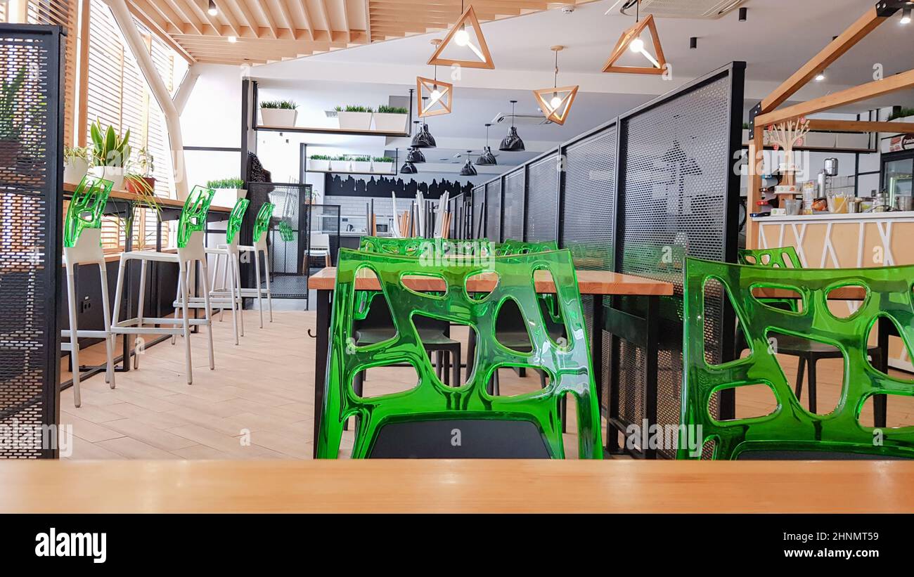 Cafeteria, no people dining room with wooden tables and green chairs ...