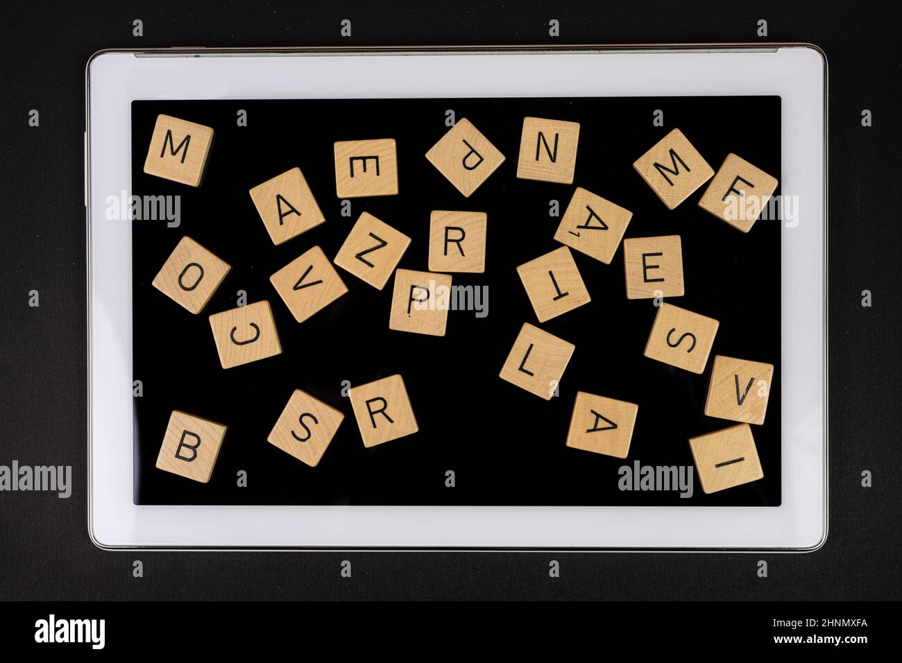 some letters of the alphabet on wooden blocks on a tablet Stock Photo ...