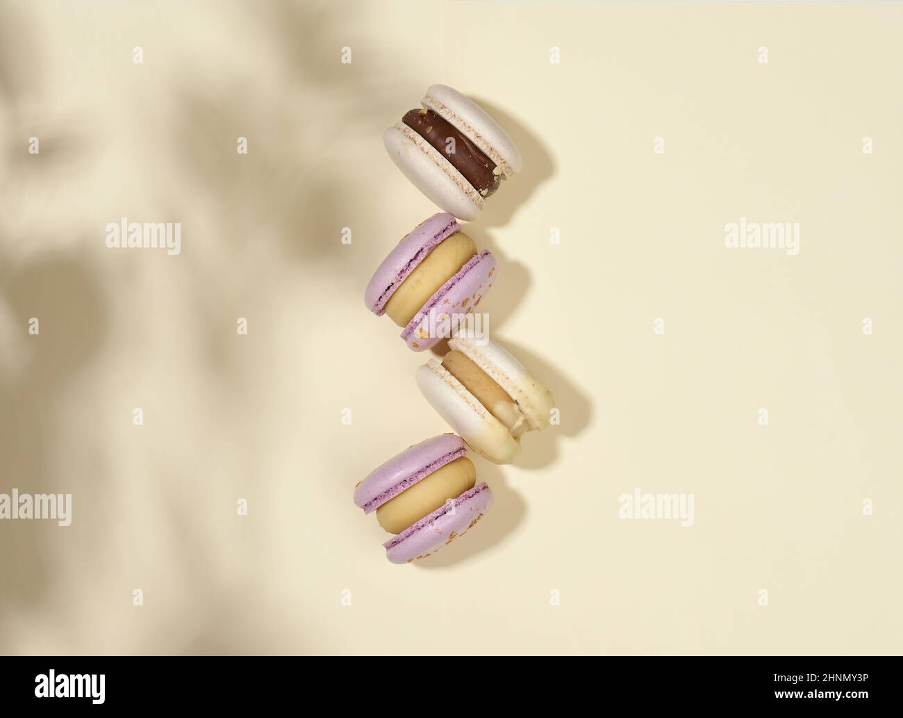 baked macarons with different flavors on a beige background, top view ...