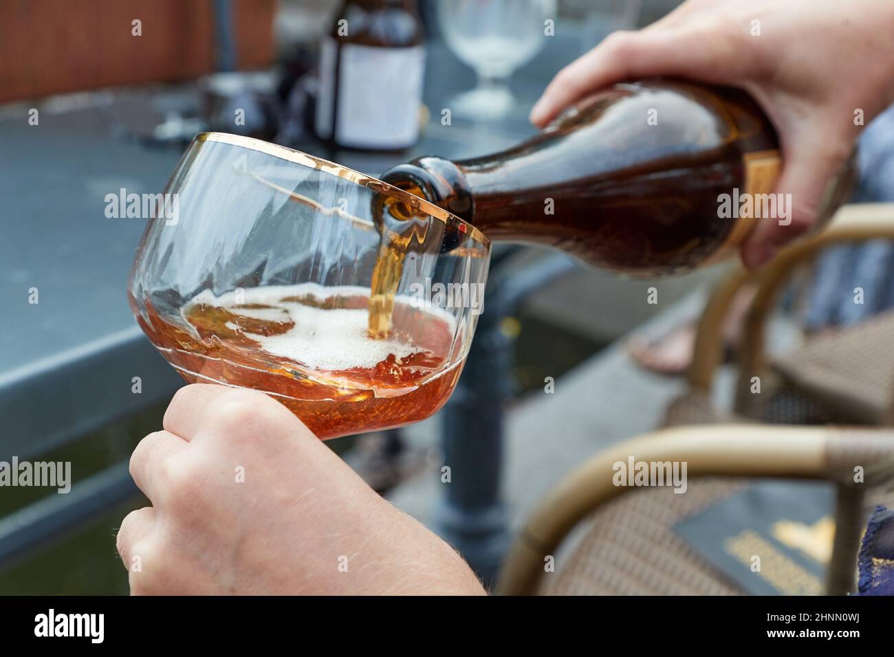 Abbey beer poured into a glass on an outdoor terrace Stock Photo - Alamy