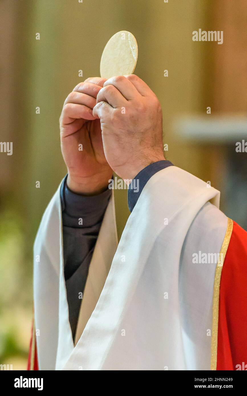 Minister showing the holy bread during the rite of the Holy Communion ...
