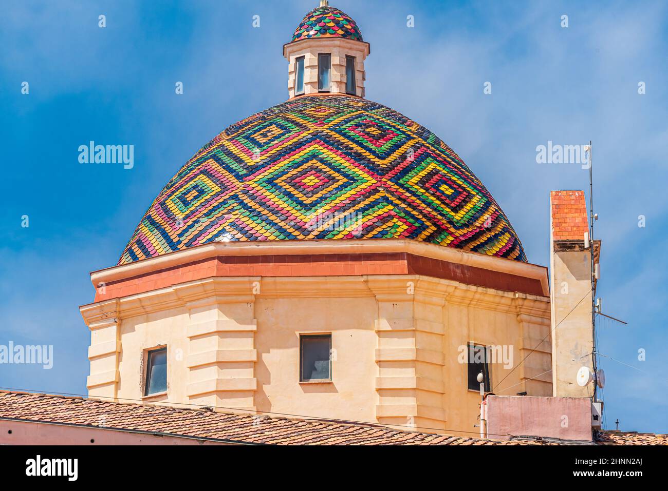 The colorful dome of a church in the old town of Alghero in Sardinia ...