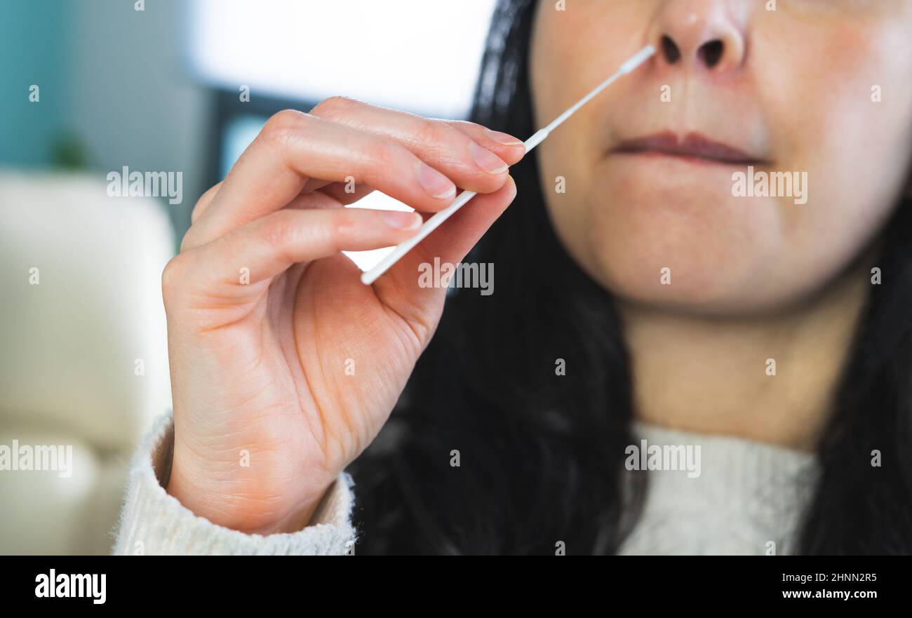 Woman taking a nasal swab for antigen testing. Covid 19 and coronavirus ...