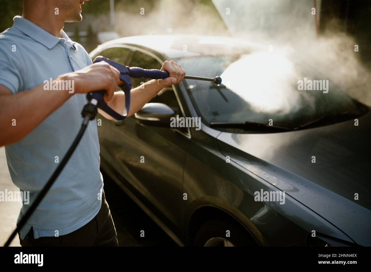 Man holds high pressure water gun, hand car wash station. Car-wash ...