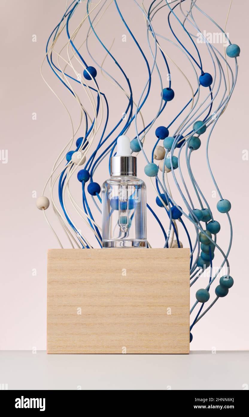 glass transparent white bottle with a pipette stands on a wooden podium ...