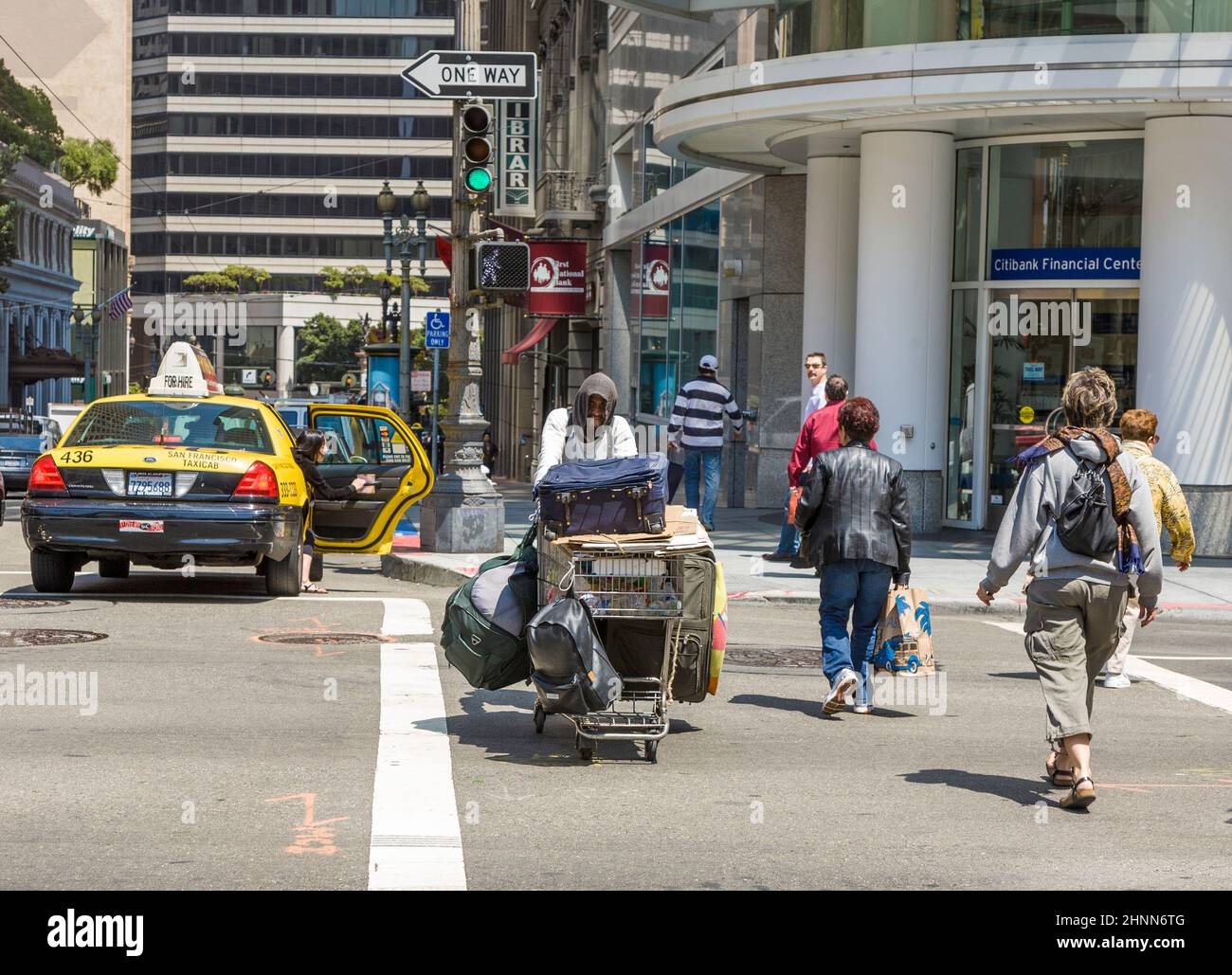homeless people cross the street at a pedestrian crossing with green ...