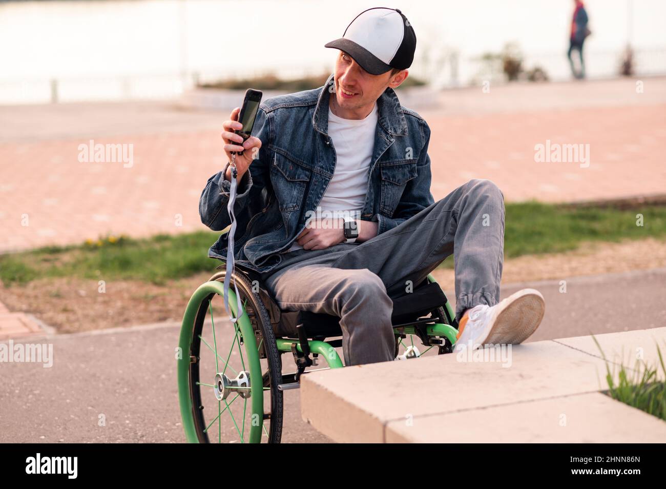 a young man in a disabled person is sitting on a bench next to a ...