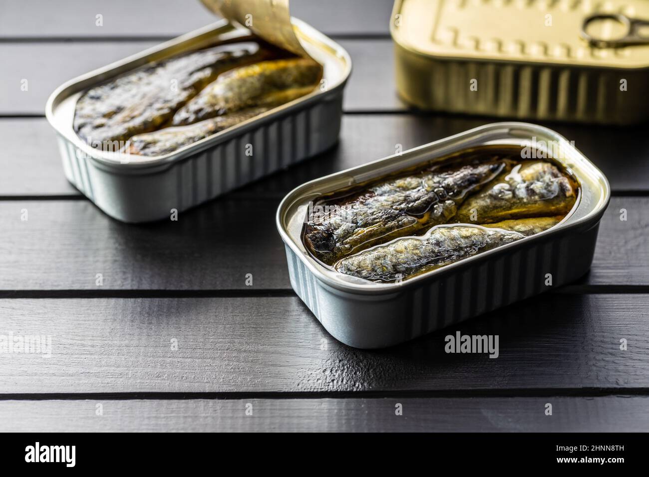Canned sardines. Sea fish in tin can on black table Stock Photo - Alamy