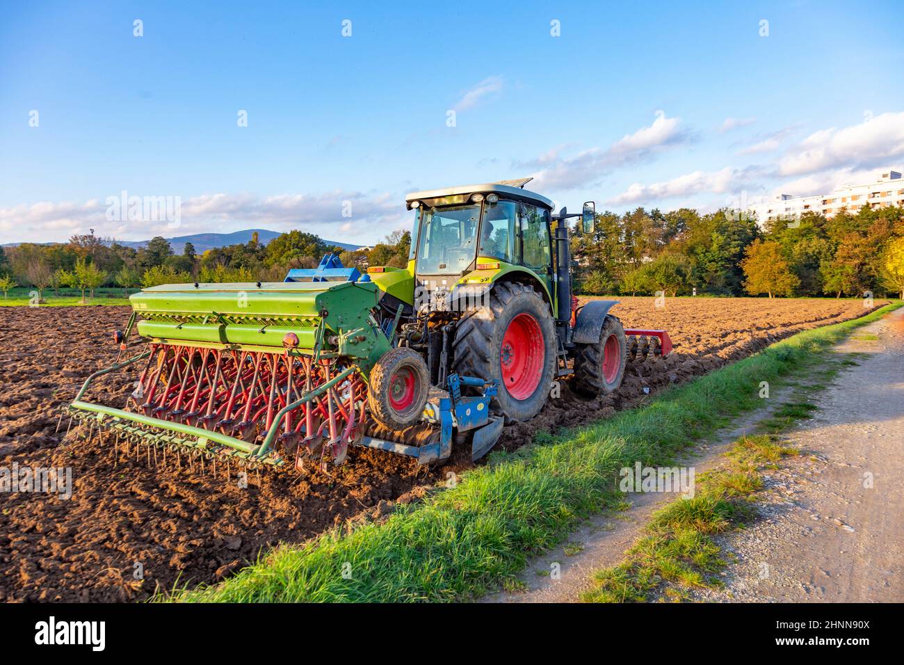 farmer plows his field with a plowing machine in spring time Stock ...