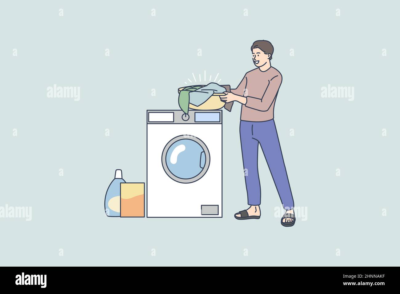 Smiling young man near washing machine do laundry wash clothes with ...
