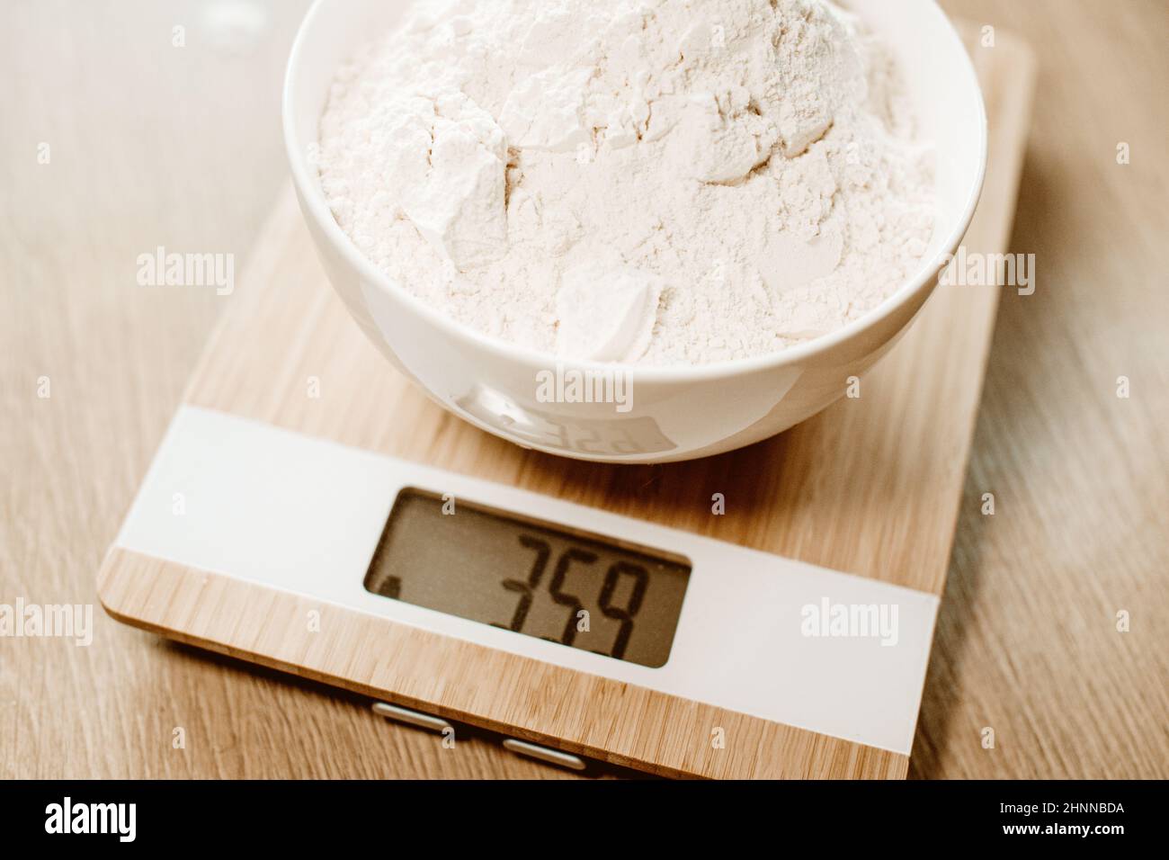 Flour in a plate stands on a kitchen scale, homemade food according to ...