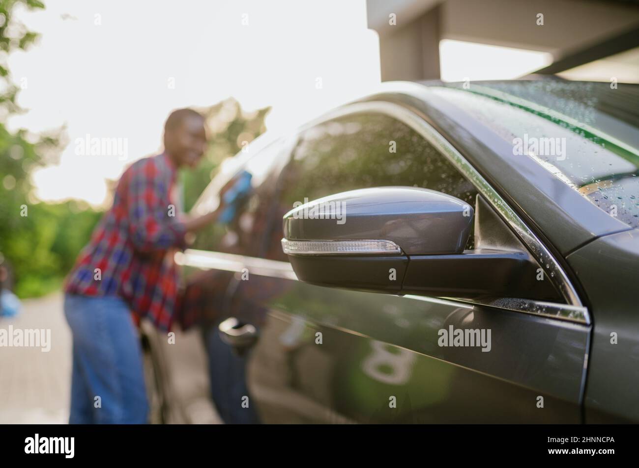 Woman wipes a car with a rag, hand auto wash station. Car-wash industry ...