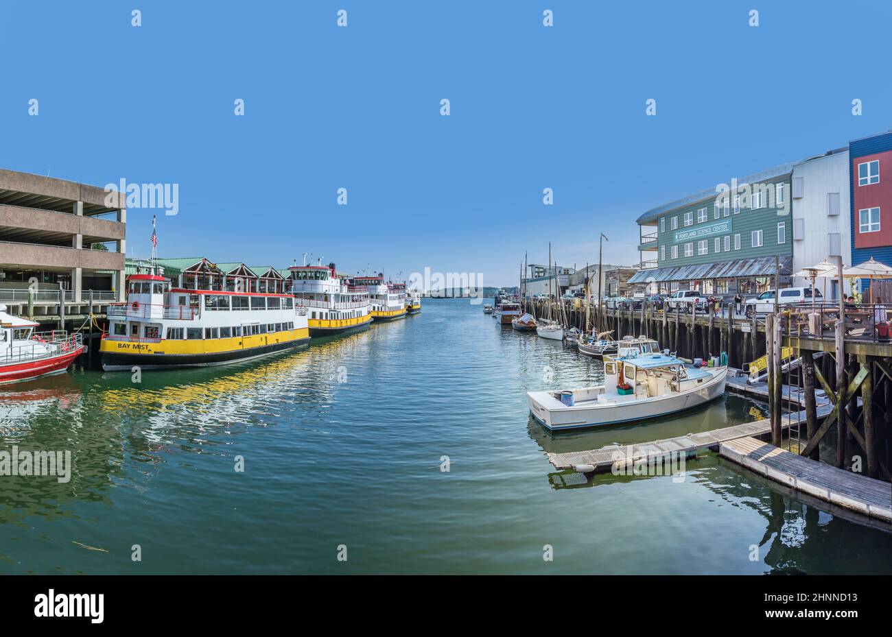 old wharf area in Portland with motorboats and old halls from fishing ...