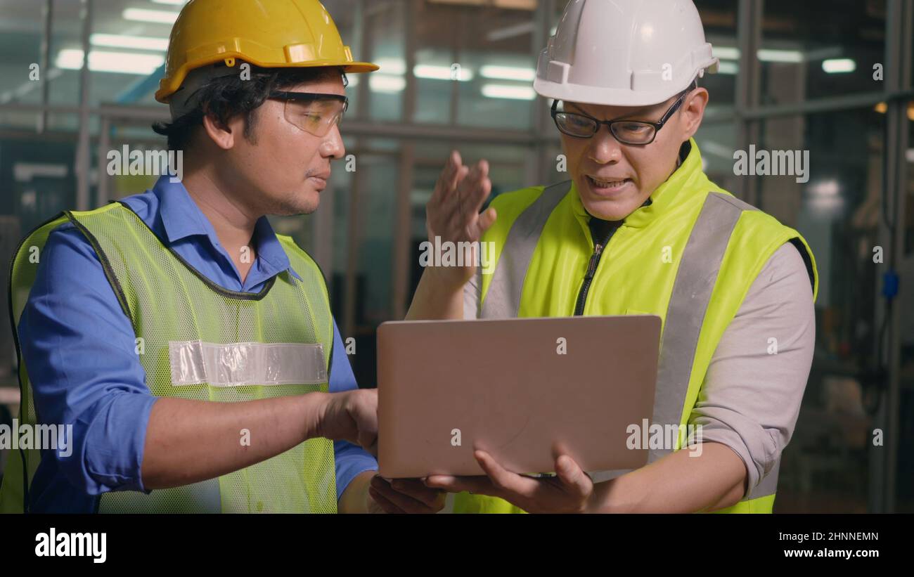 Two factory industrial workers technician or engineer and manager wear ...