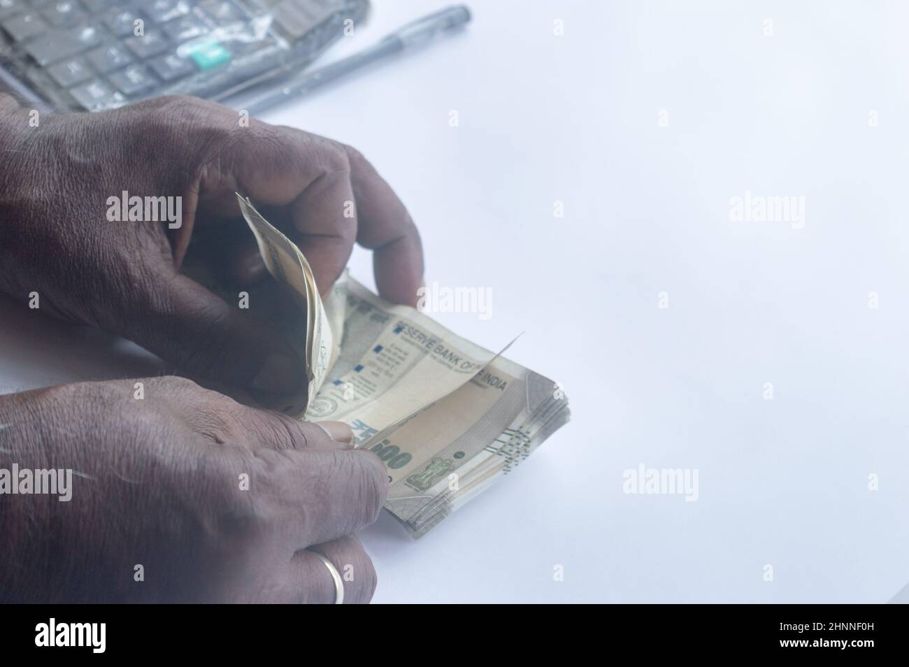 Senior aged Man hand counting Indian rupee note on table. High angle ...