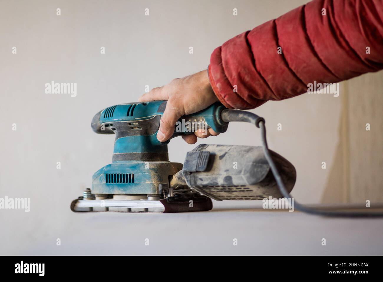 Man sanding wood plank using electric sand machine Stock Photo - Alamy