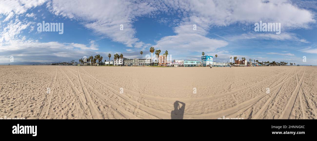 people enjoy scenic beach promenade with palms and colorful houses at ...