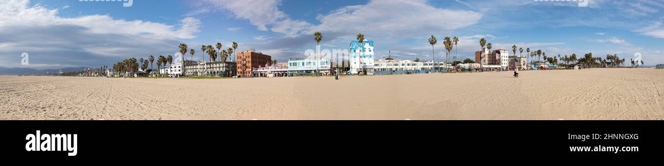people enjoy scenic beach promenade with palms and colorful houses at ...