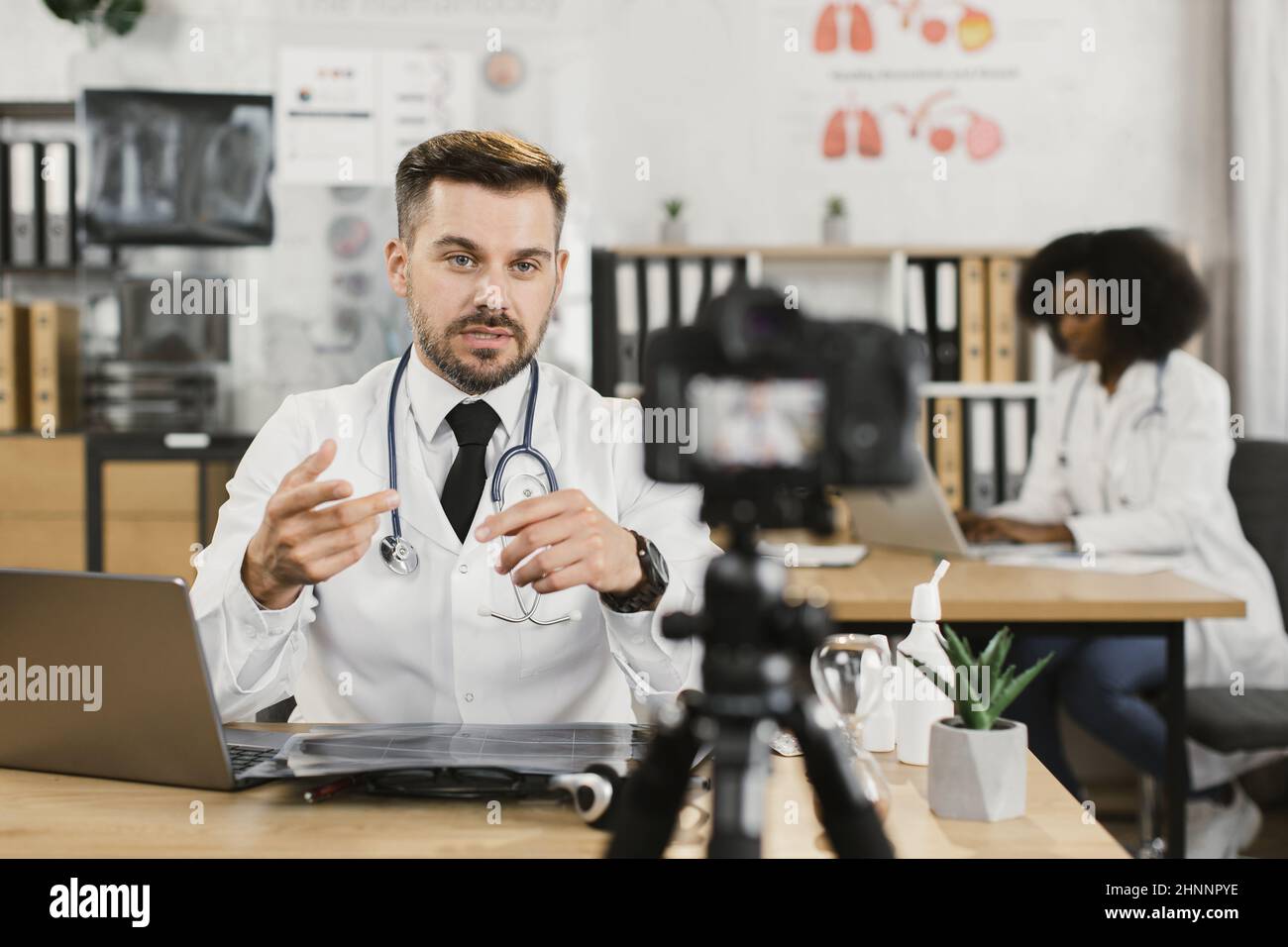 Qualified caucasian doctor in white lab coat using laptop and digital ...
