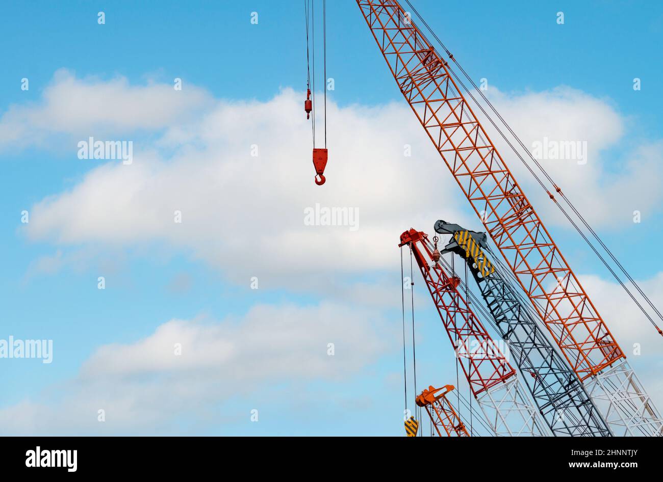 Crawler crane against blue sky and white clouds. Real estate industry ...