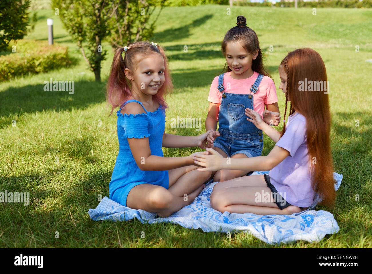 happy cute children girls playing together in the park on grass on ...