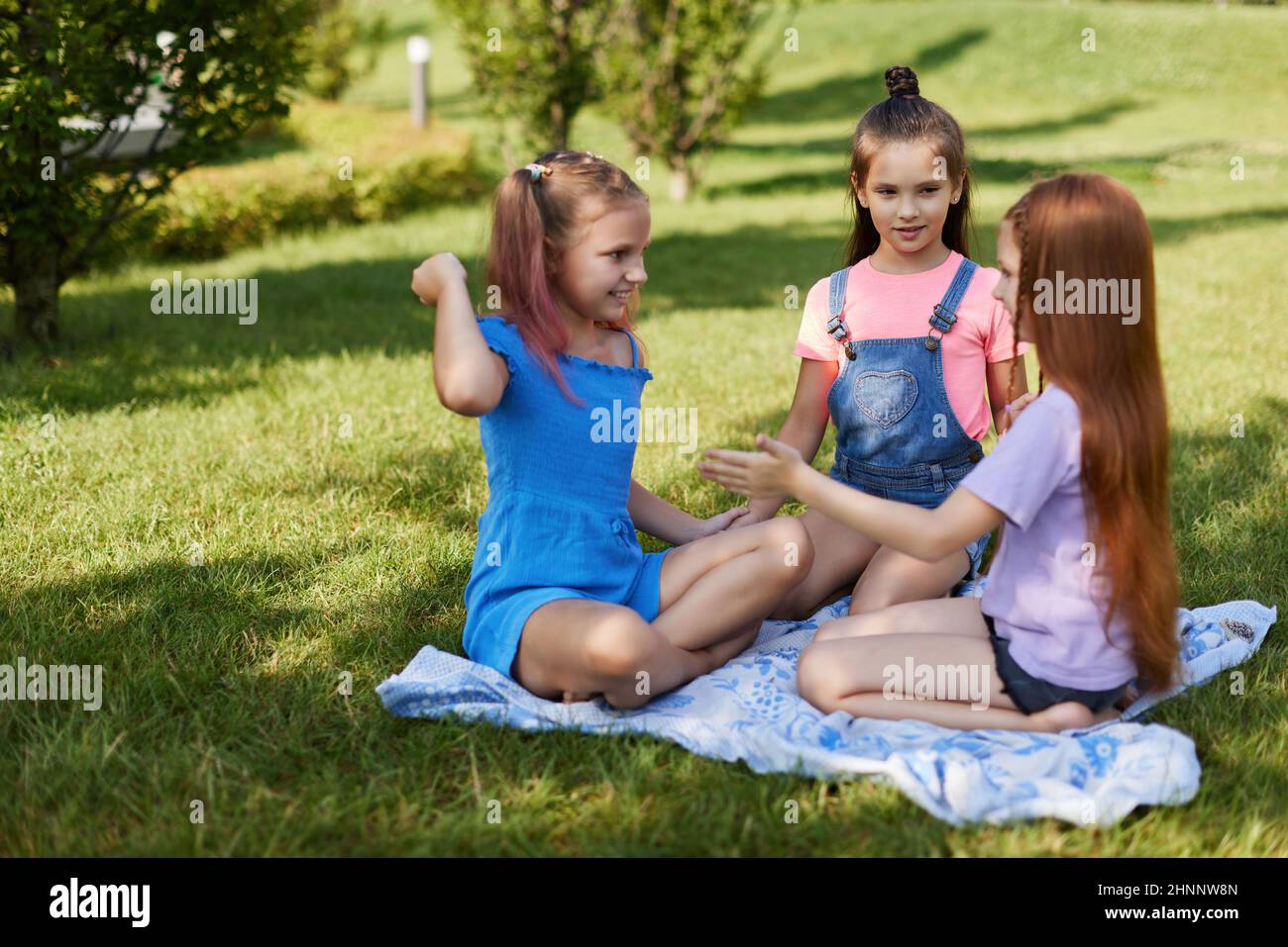 happy cute children girls playing together in the park on grass on ...