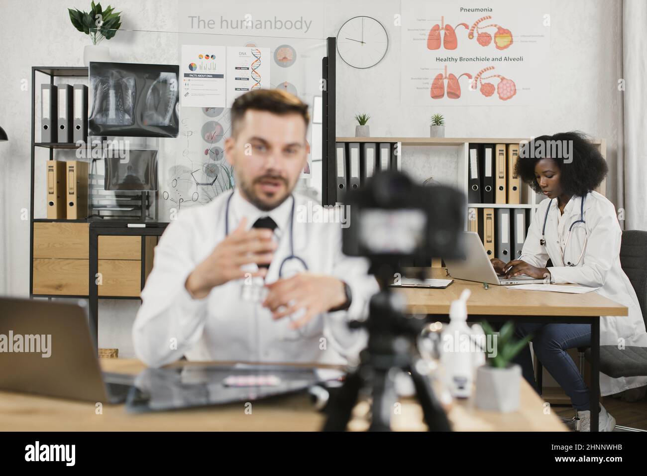African american nurse typing on modern laptop while qualified ...