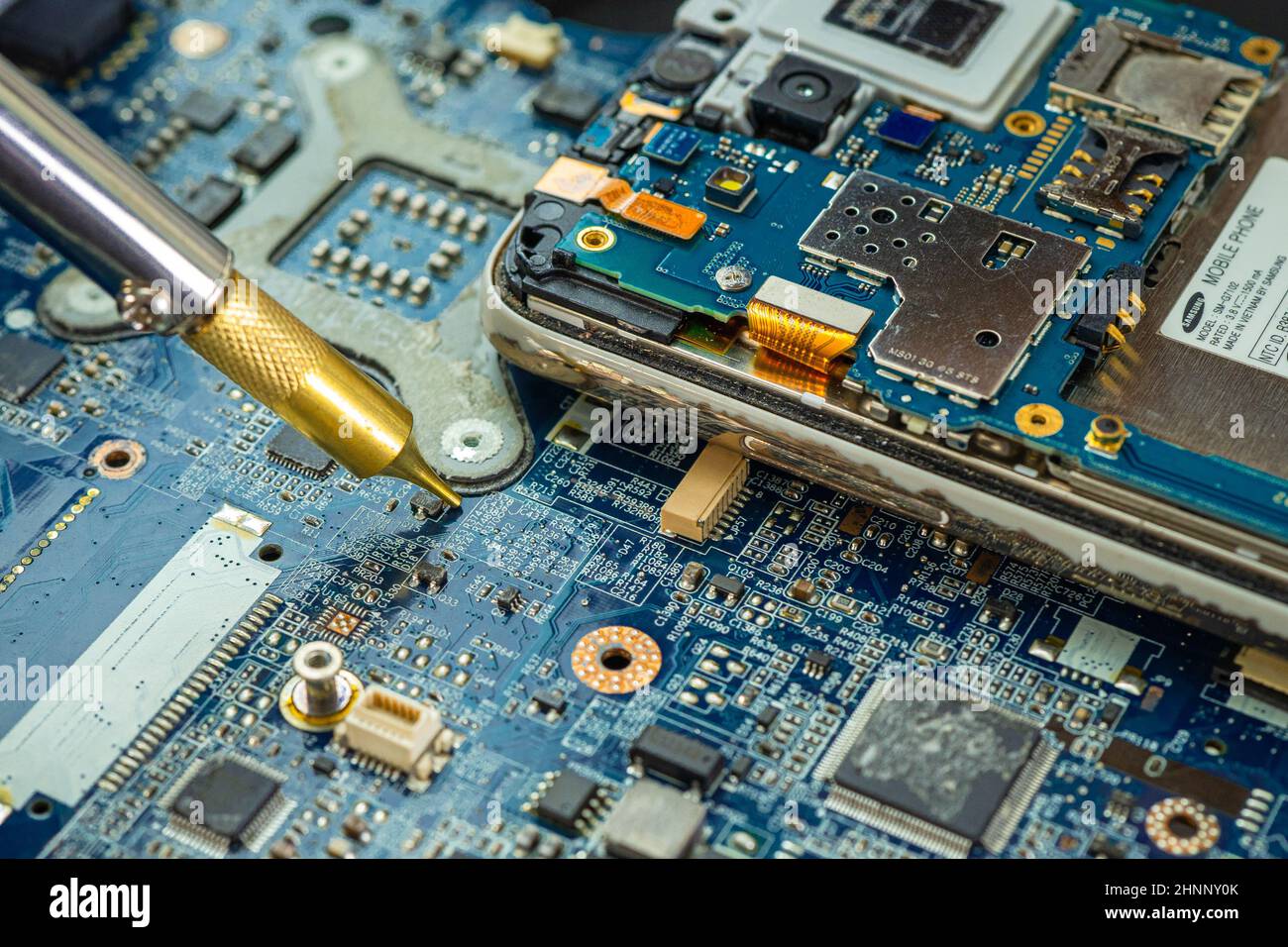 technician repairing inside of hard disk by soldering iron. Integrated ...