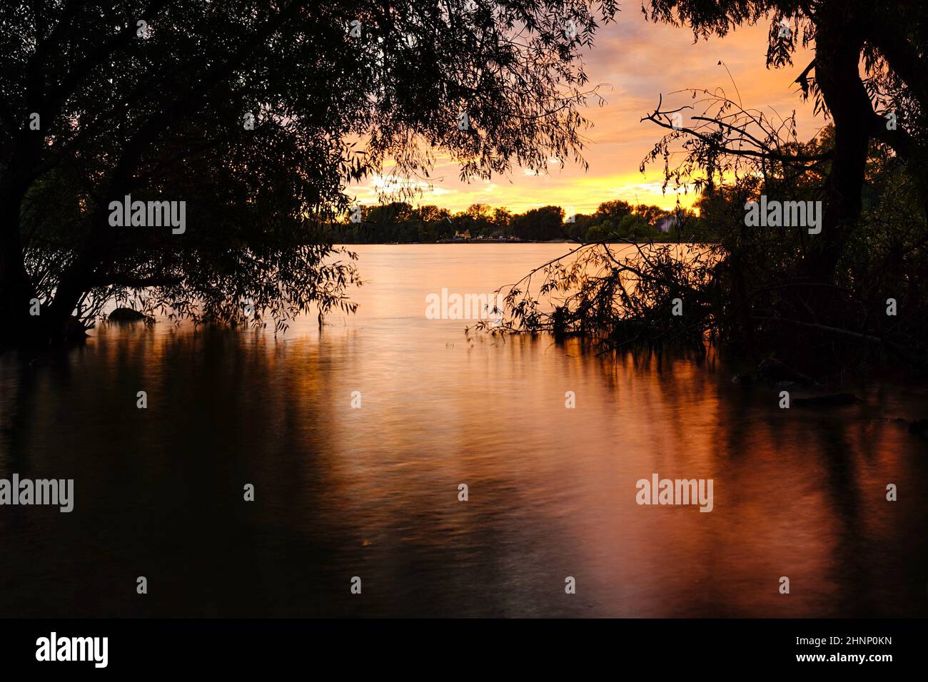A fantastic sunset at river Rhine. Orange and red clouds reflecting in ...