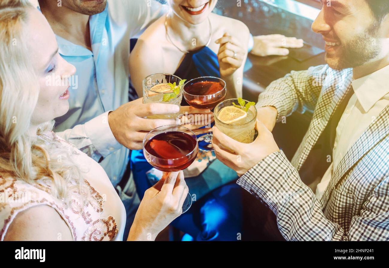 Women and men in a bar clinking glasses with cocktails Stock Photo - Alamy