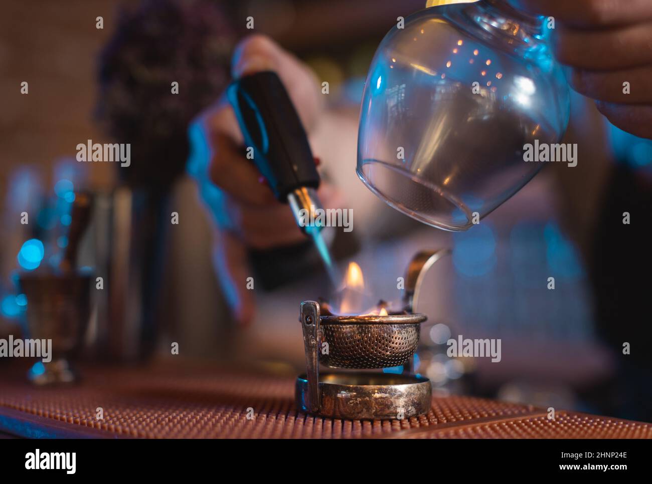 Closeup of male hands using professional burner to prepare drink with ...