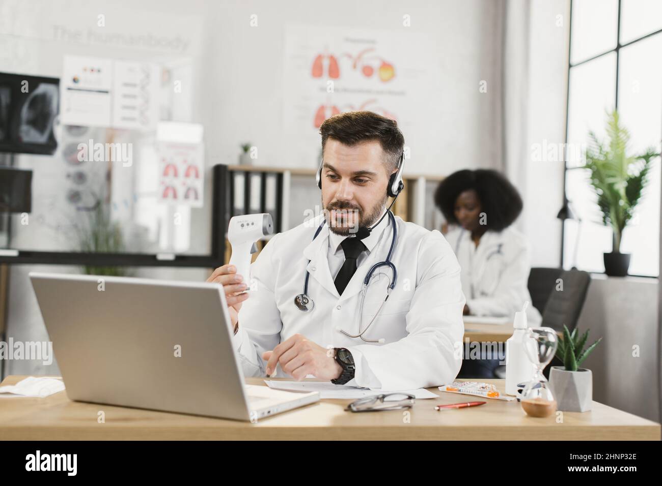 Caucasian male doctor in headset explaining patient about using of ...