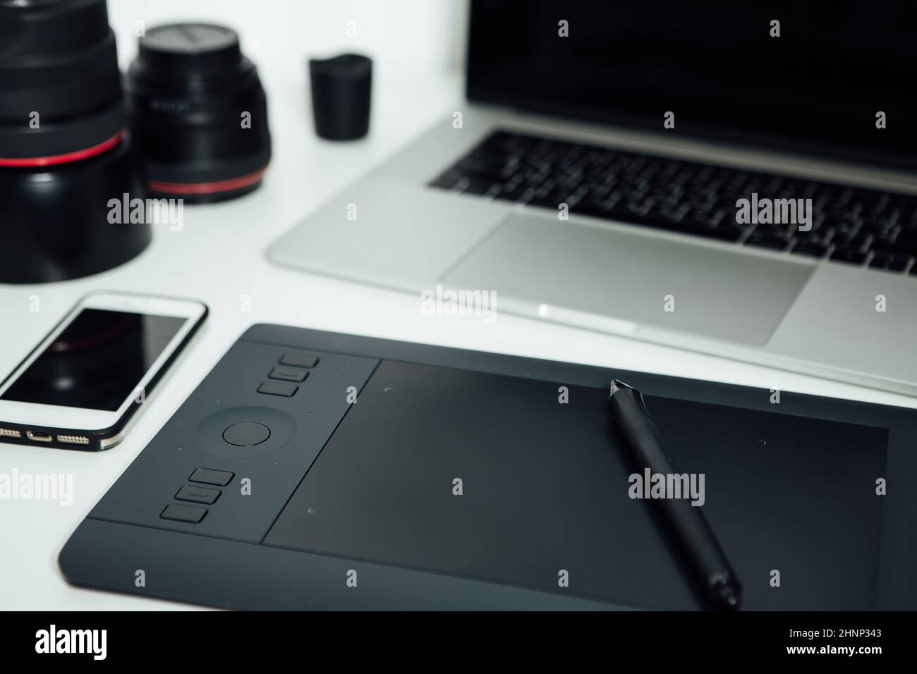 Workspace of professional retoucher. laptop, stylus and tablet for ...