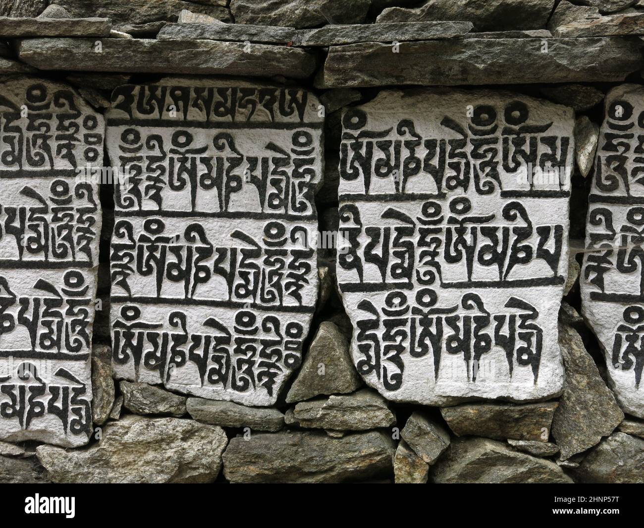 Mani wall, buddhist mantra carved in stones, Nepal Stock Photo - Alamy