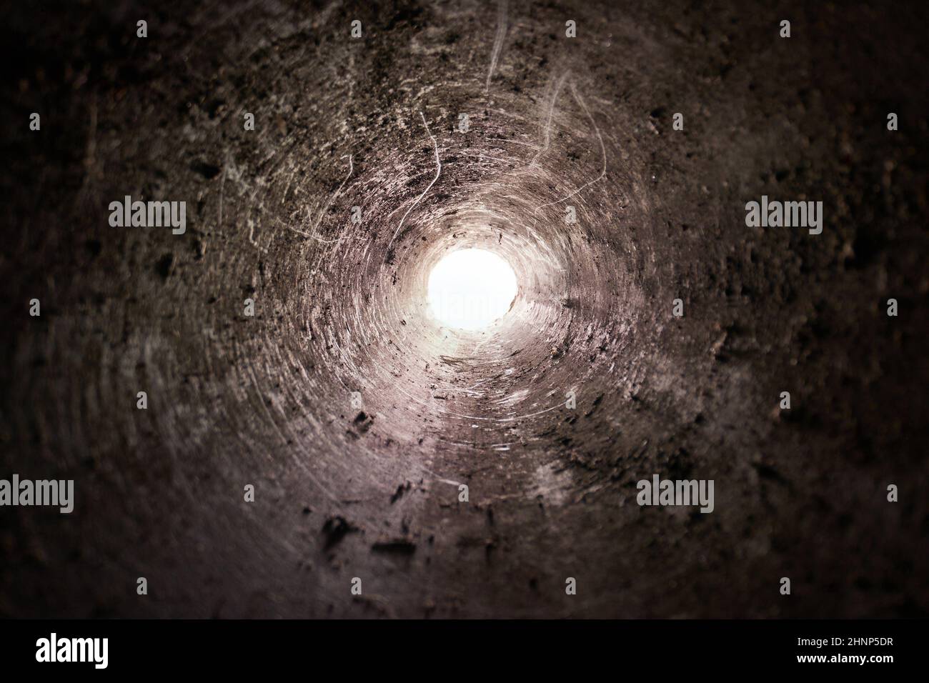 Dirty dark tube interior with light in the end, fallen int deep well ...