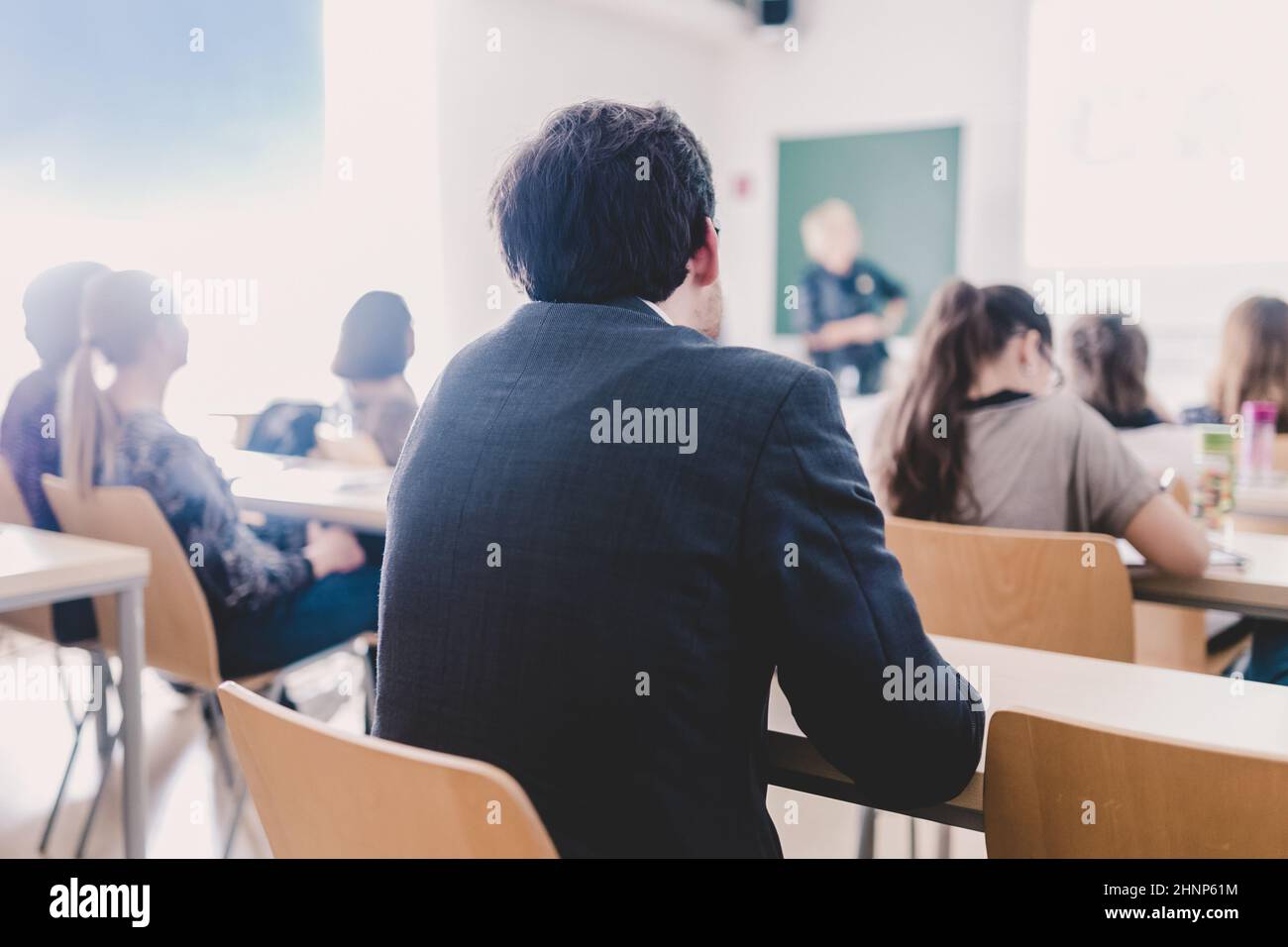 Teacher at university in front of a whiteboard screen. Students ...