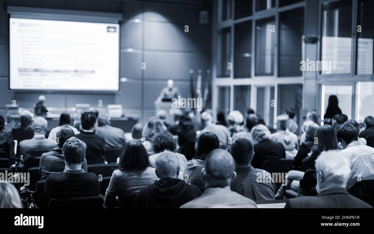 Audience in lecture hall participating at business event Stock Photo ...