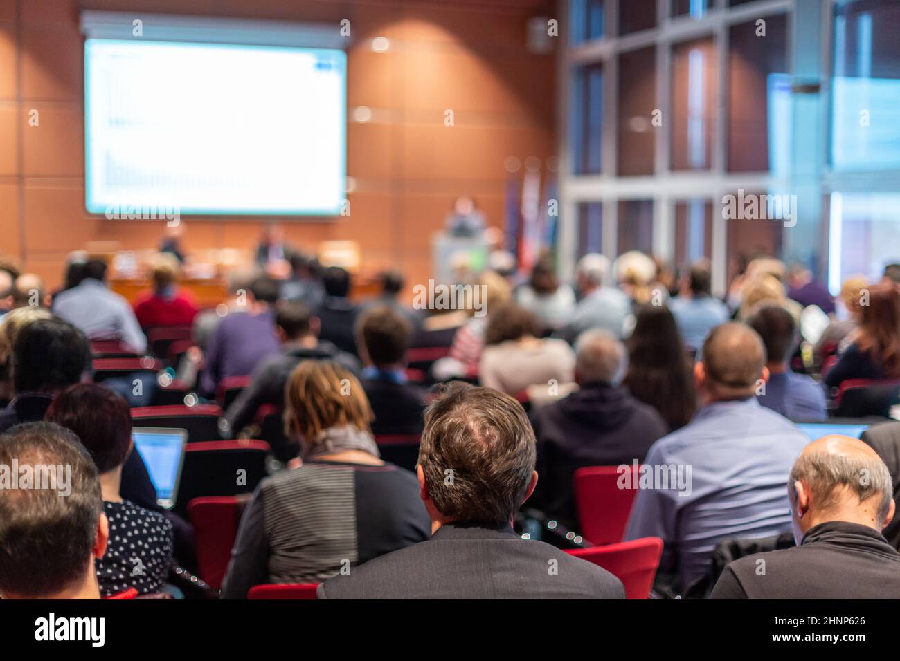 Audience in lecture hall participating at business event Stock Photo ...