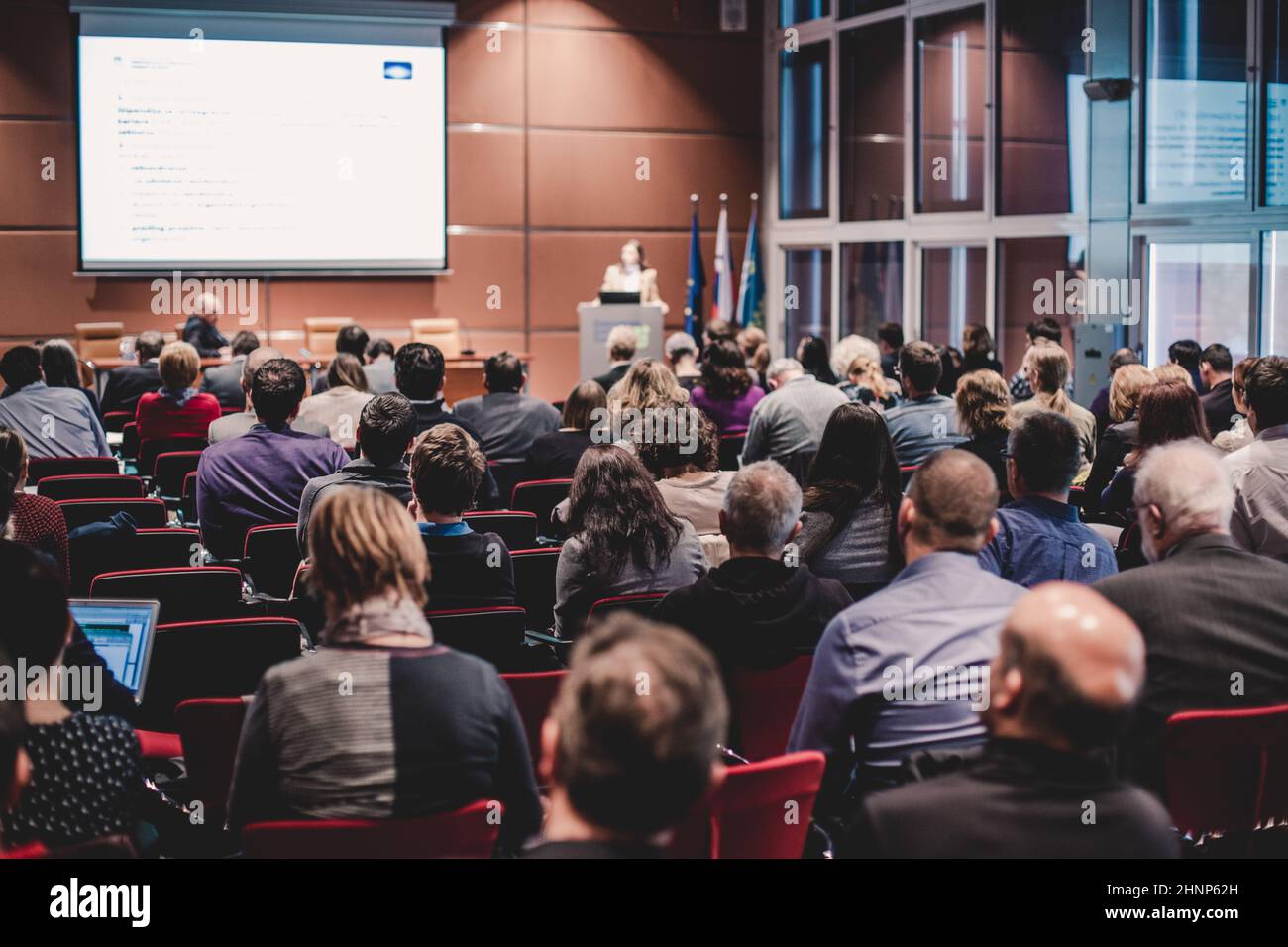 Audience in lecture hall participating at business event Stock Photo ...