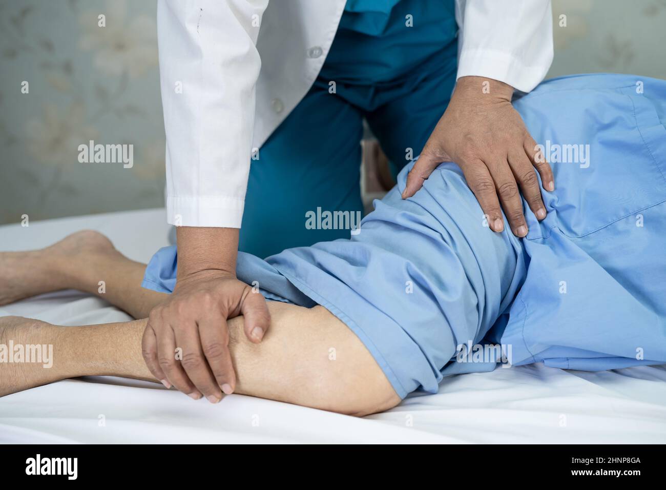 Physiotherapist doing physical therapy in rehab with patient in nursing ...